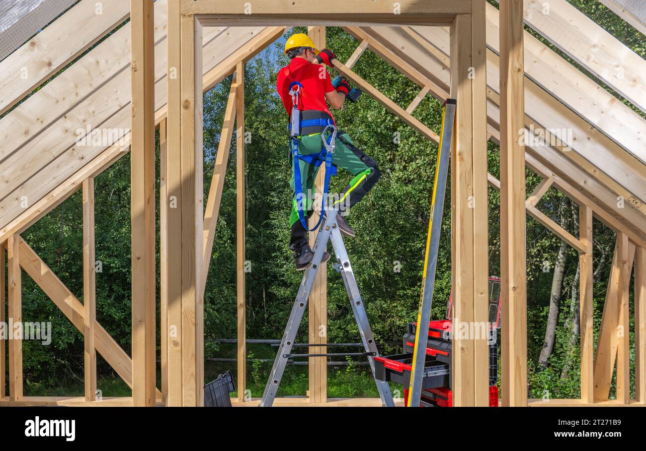 Construction Site Worker in his 40s Building Wooden House Frame ...