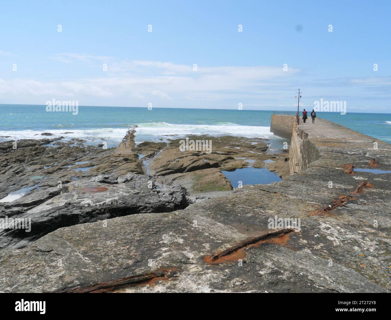 A concrete covered drain pipe leads into the sea at Porthleven harbor ...