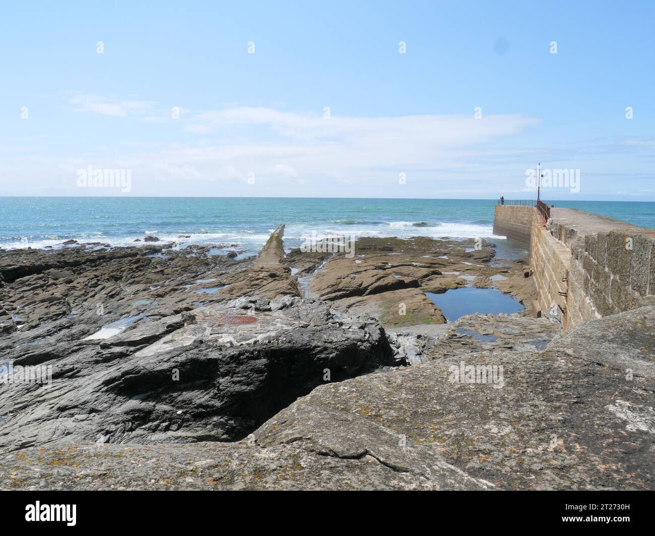 A concrete covered drain pipe leads into the sea at Porthleven harbor ...