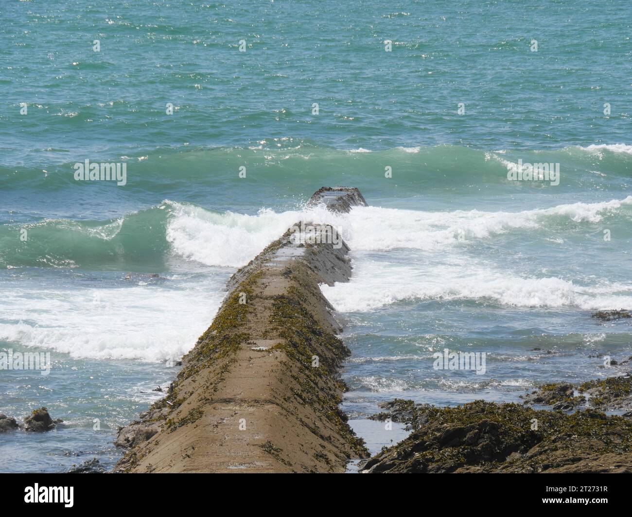 A concrete covered drain pipe leads into the sea at Porthleven harbor ...