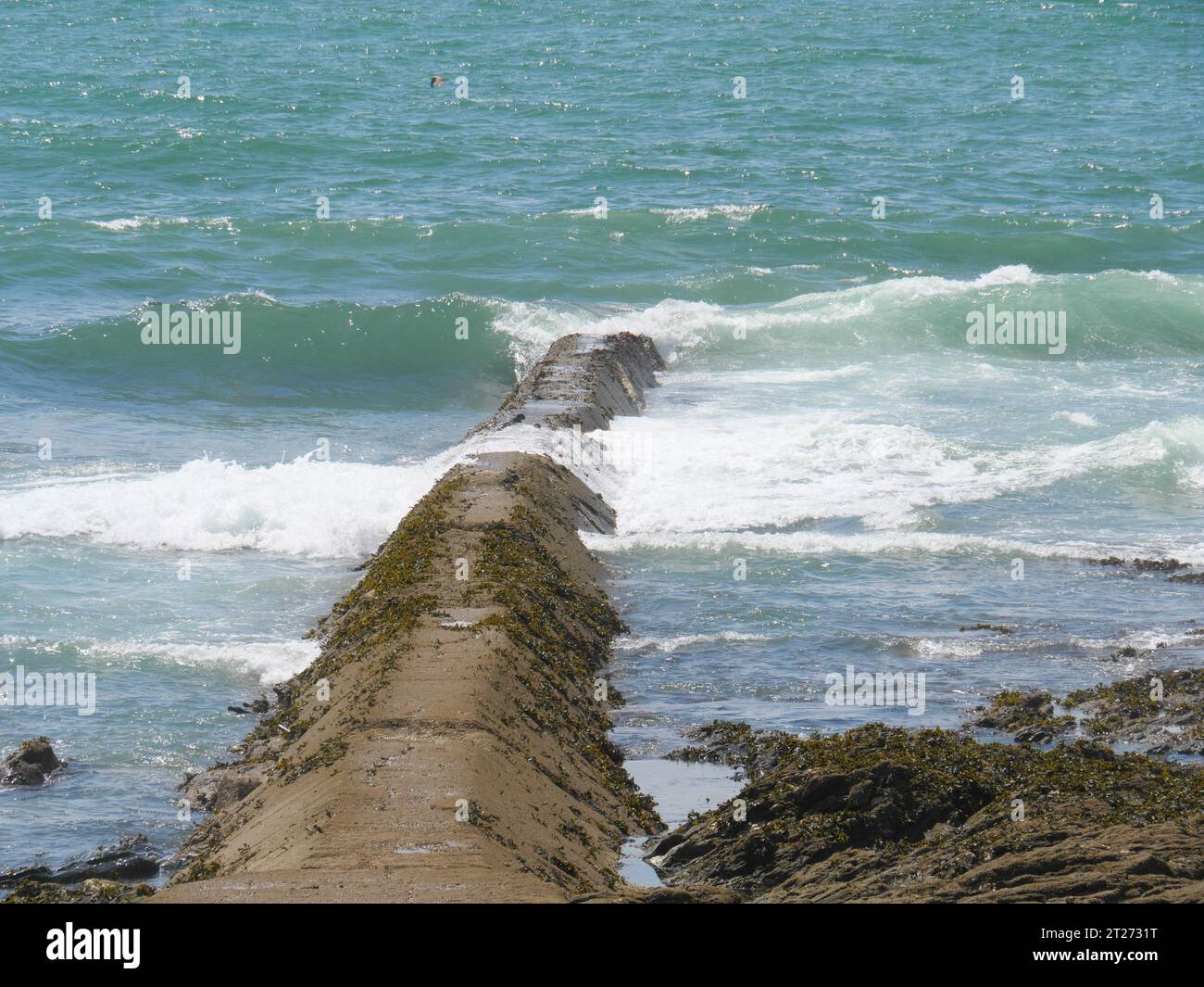 A concrete covered drain pipe leads into the sea at Porthleven harbor ...