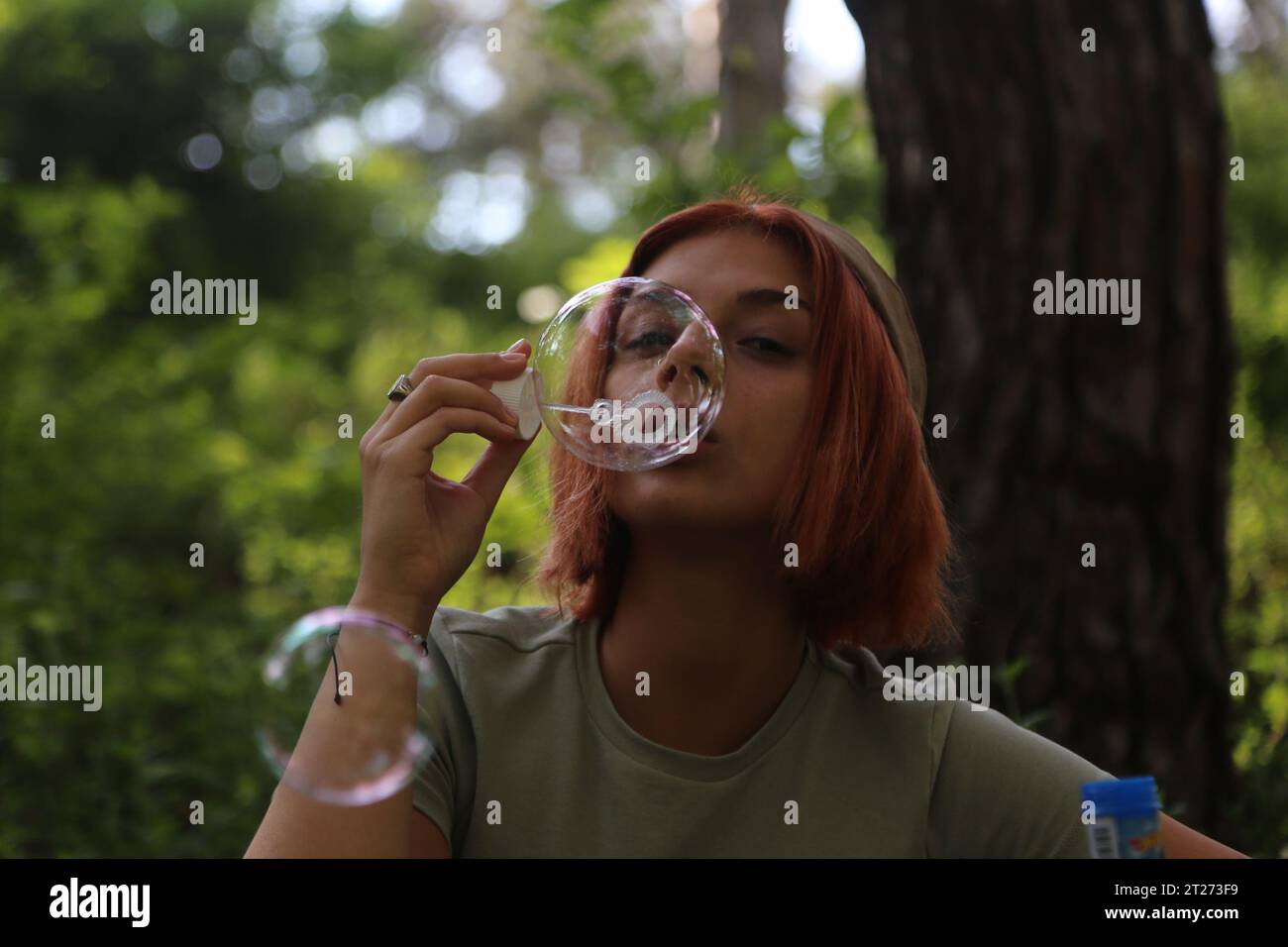 Ginger woman blowing bubbles Stock Photo - Alamy