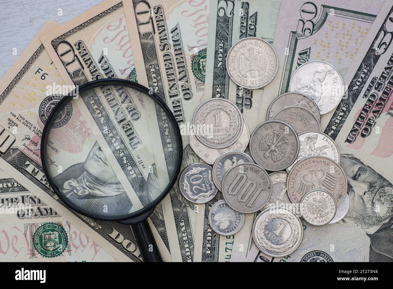 Paper dollars and various metal coins under a magnifying glass Stock ...