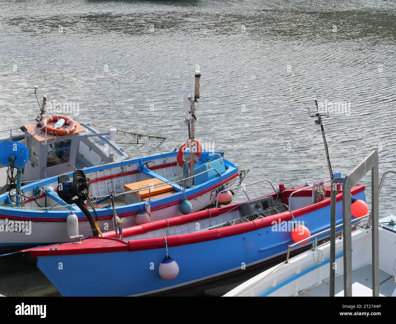 colorful fishing boats lying side by side in the harbor of Porthleven ...