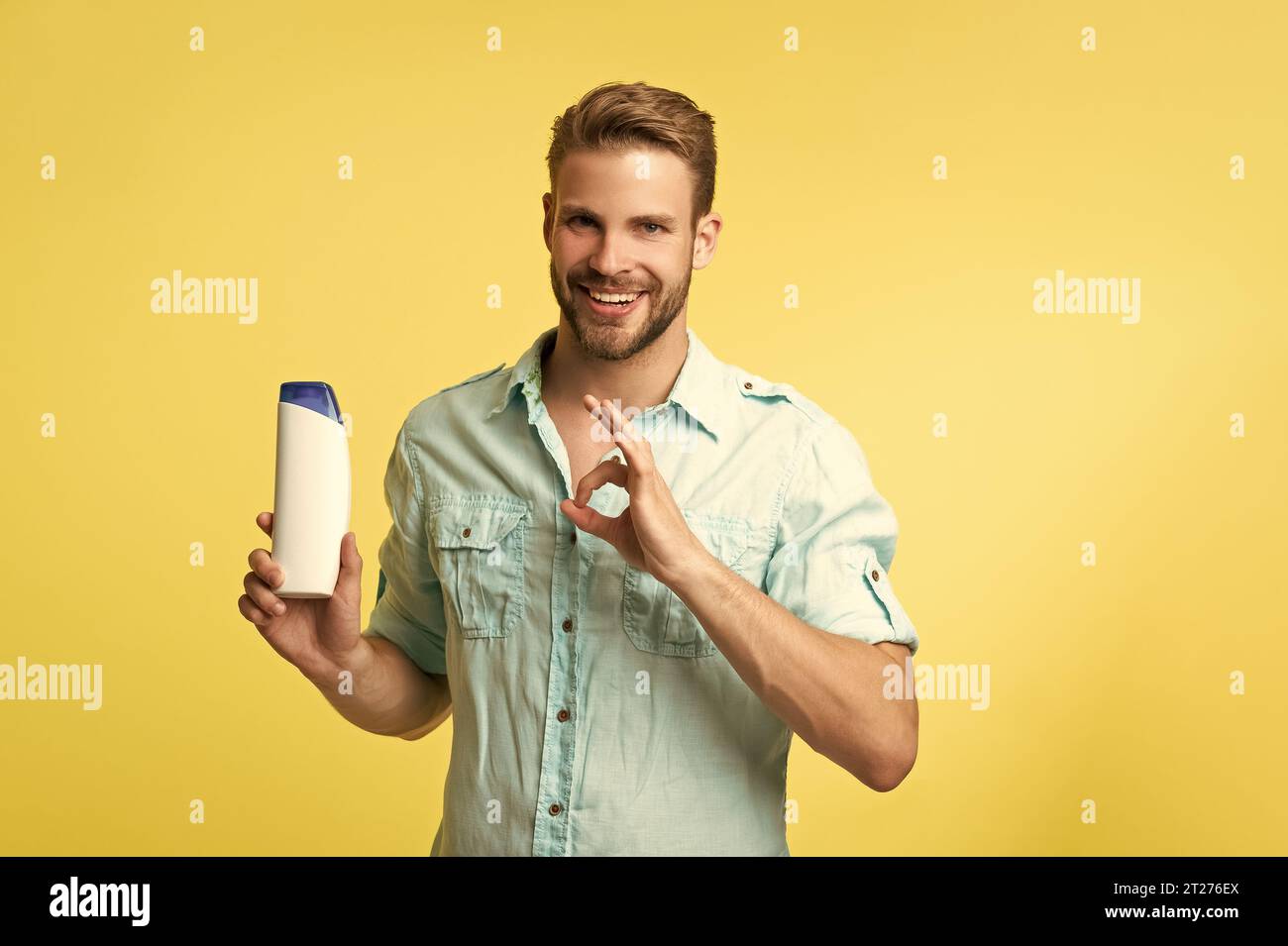 happy man hold shampoo cosmetics in studio background Stock Photo - Alamy