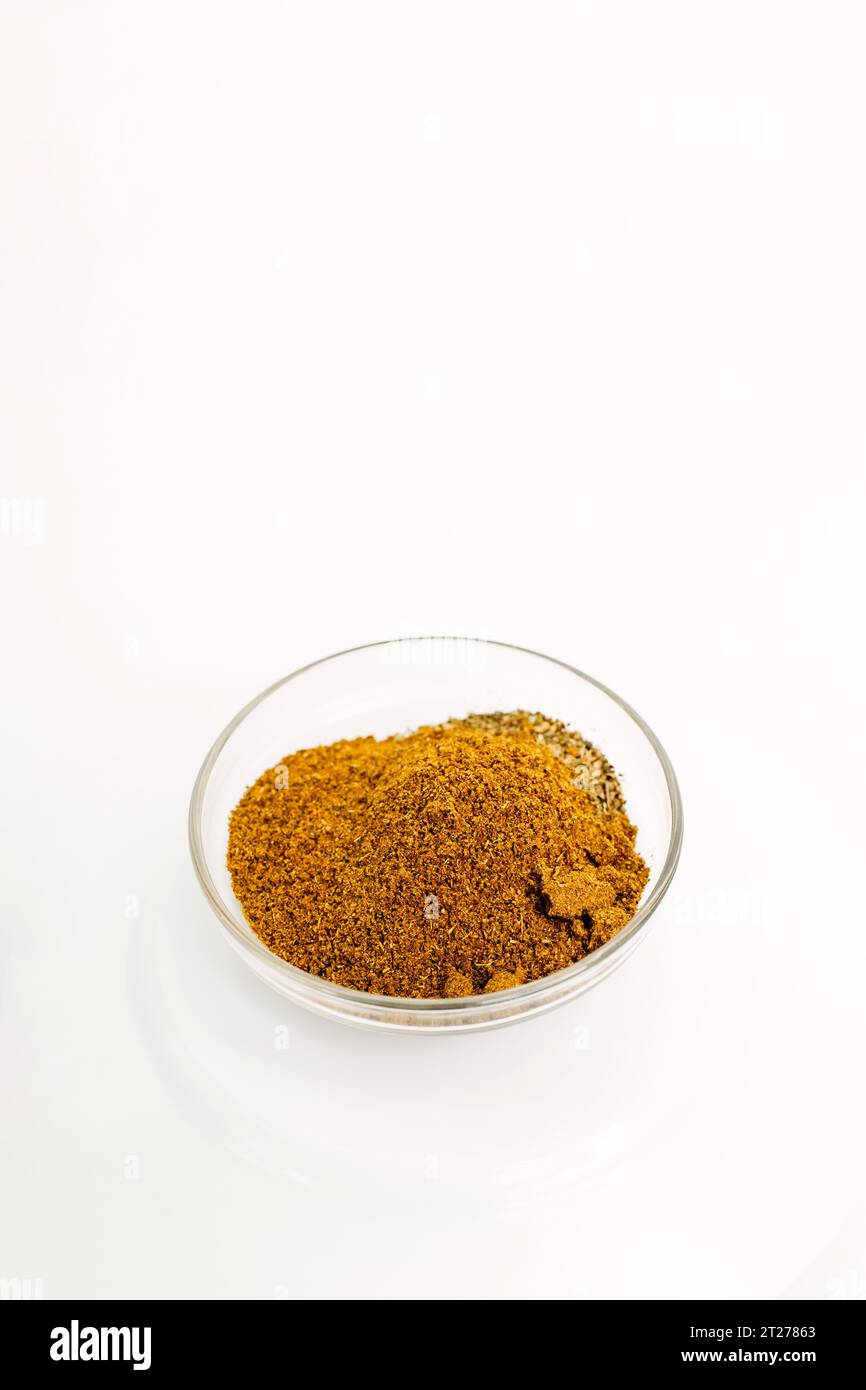 Homemade spice mixture in a glass plate on a white background. Close-up ...