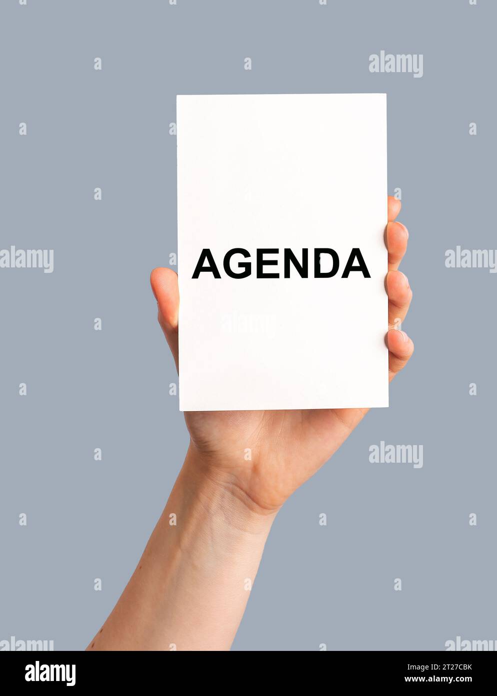 Agenda word on paper card in hand Stock Photo - Alamy