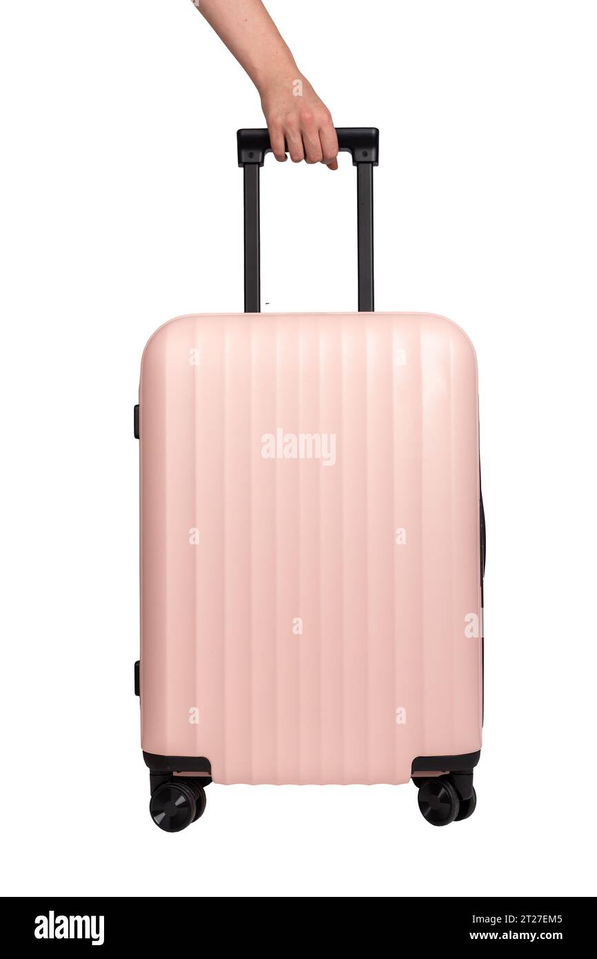 Hand holding handle of wheeled suitcase, spinner luggage, pink bag ...