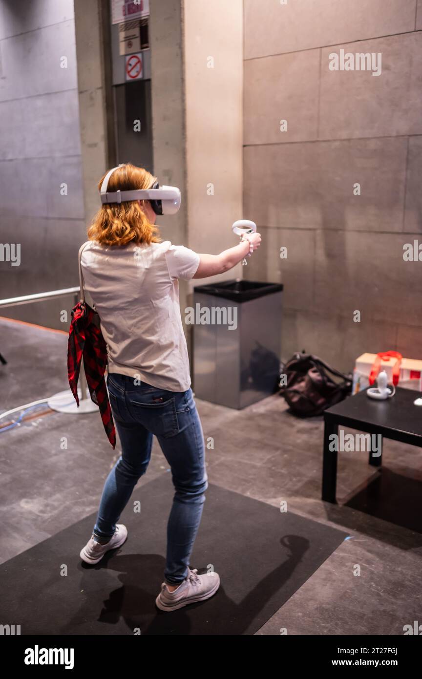 Young woman playing with Meta Quest 2 all-in-one VR headset during ...