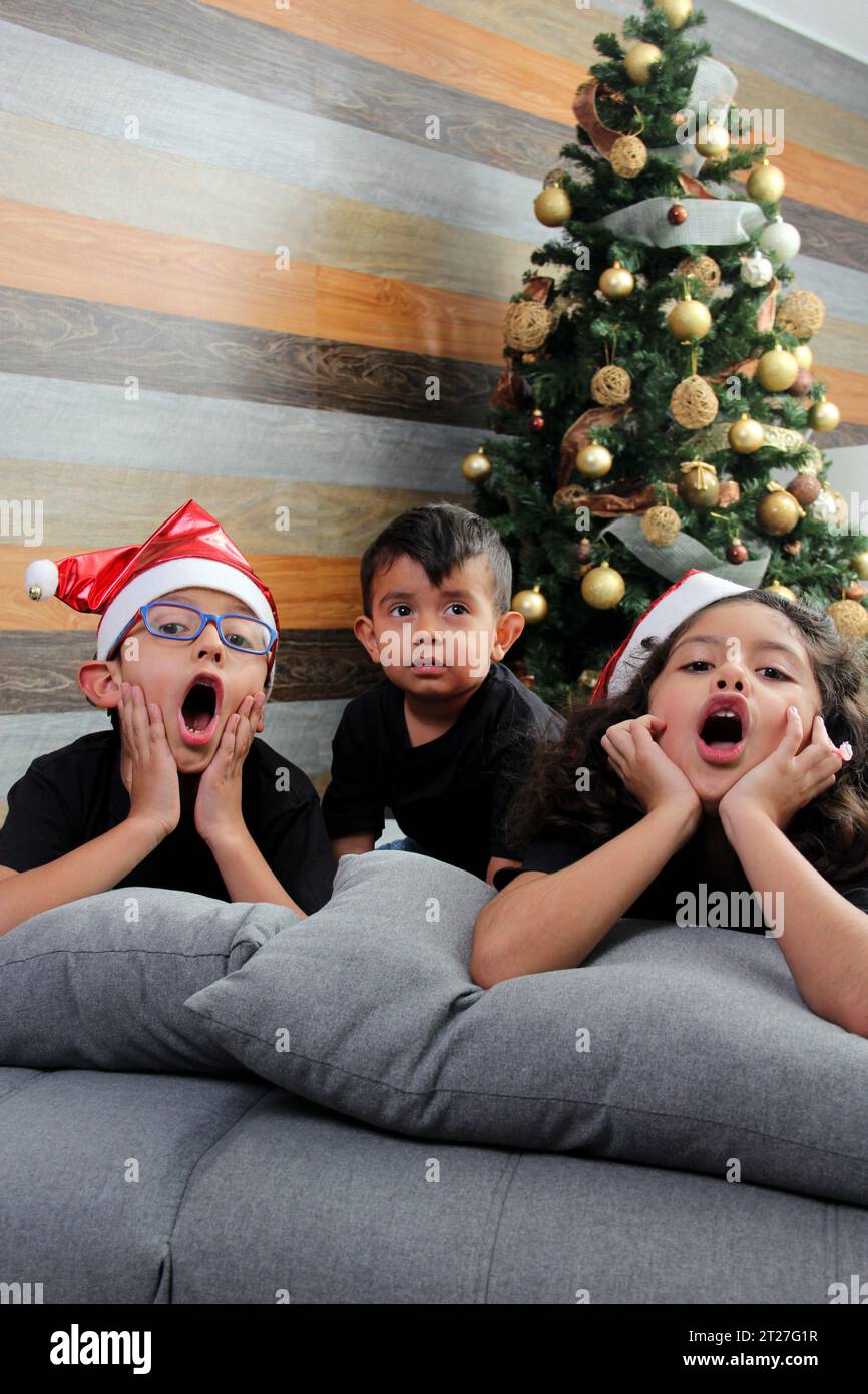 Three little dark-skinned Latino brothers wait for Santa Claus and the ...