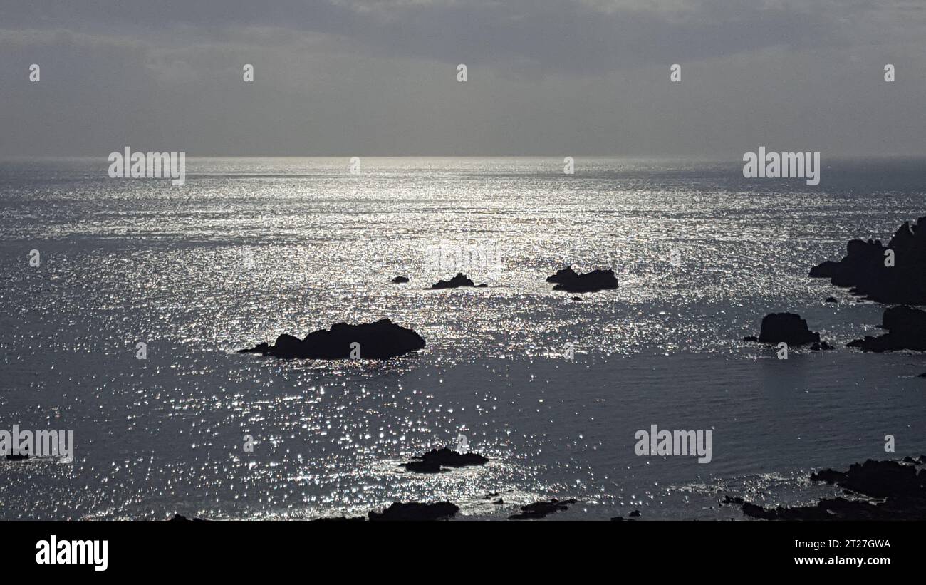 A tranquil ocean glistening in the sun, its crystal-clear waters ...