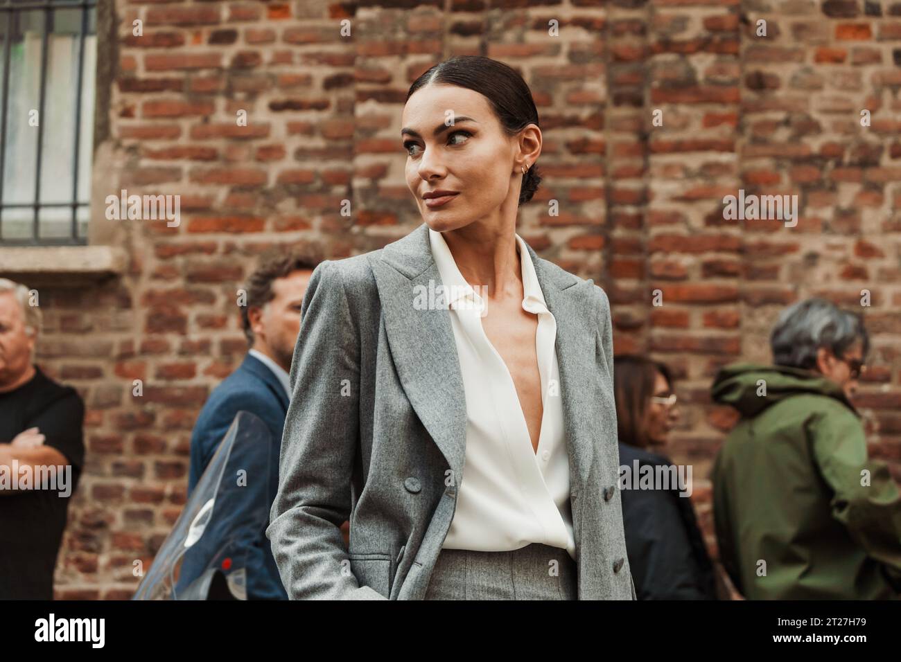 Paola Turani wears gray suit and white blouse, outside MAX MARA show ...