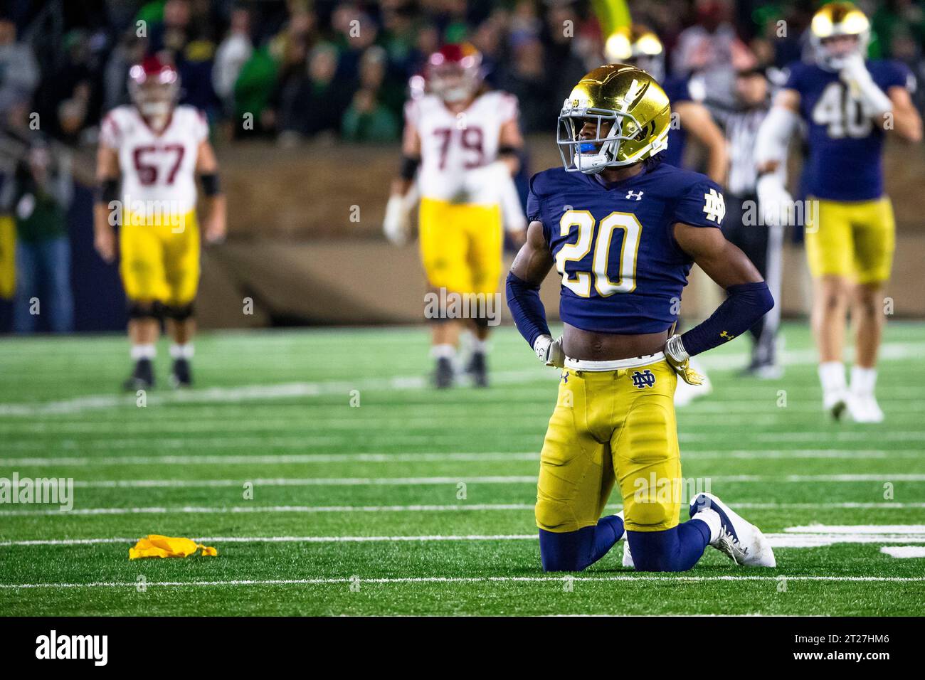 Notre Dame cornerback Benjamin Morrison (20) kneels next to a flag ...