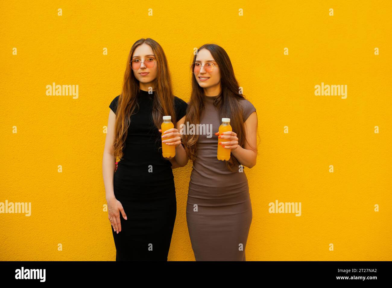 Connection between amazed urban young twin sisters with cool sunglasses ...