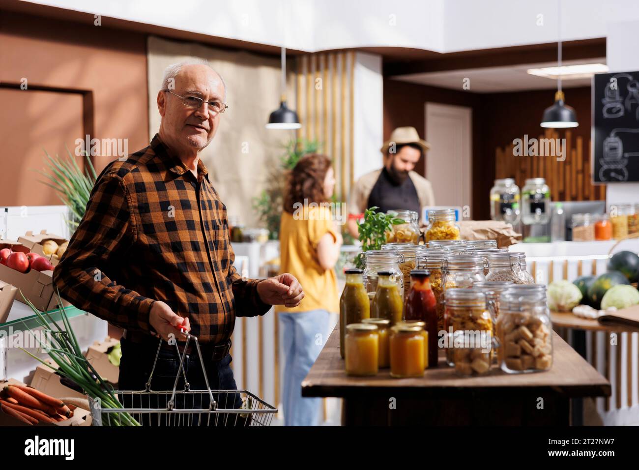 Portrait of elderly man looking for fresh vegetables in eco friendly ...