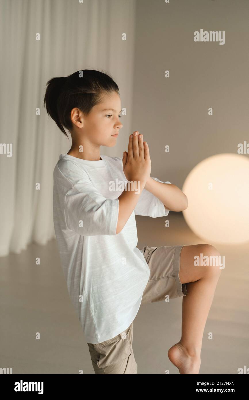 A child practices yoga poses indoors. Children's yoga Stock Photo - Alamy