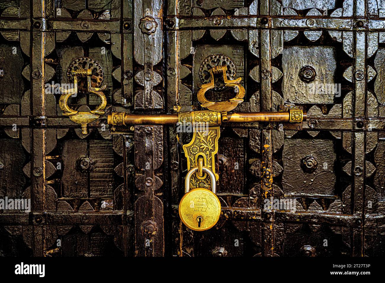 Ornate brass sliding bolt lock on a carved wooden door at the Ajit ...