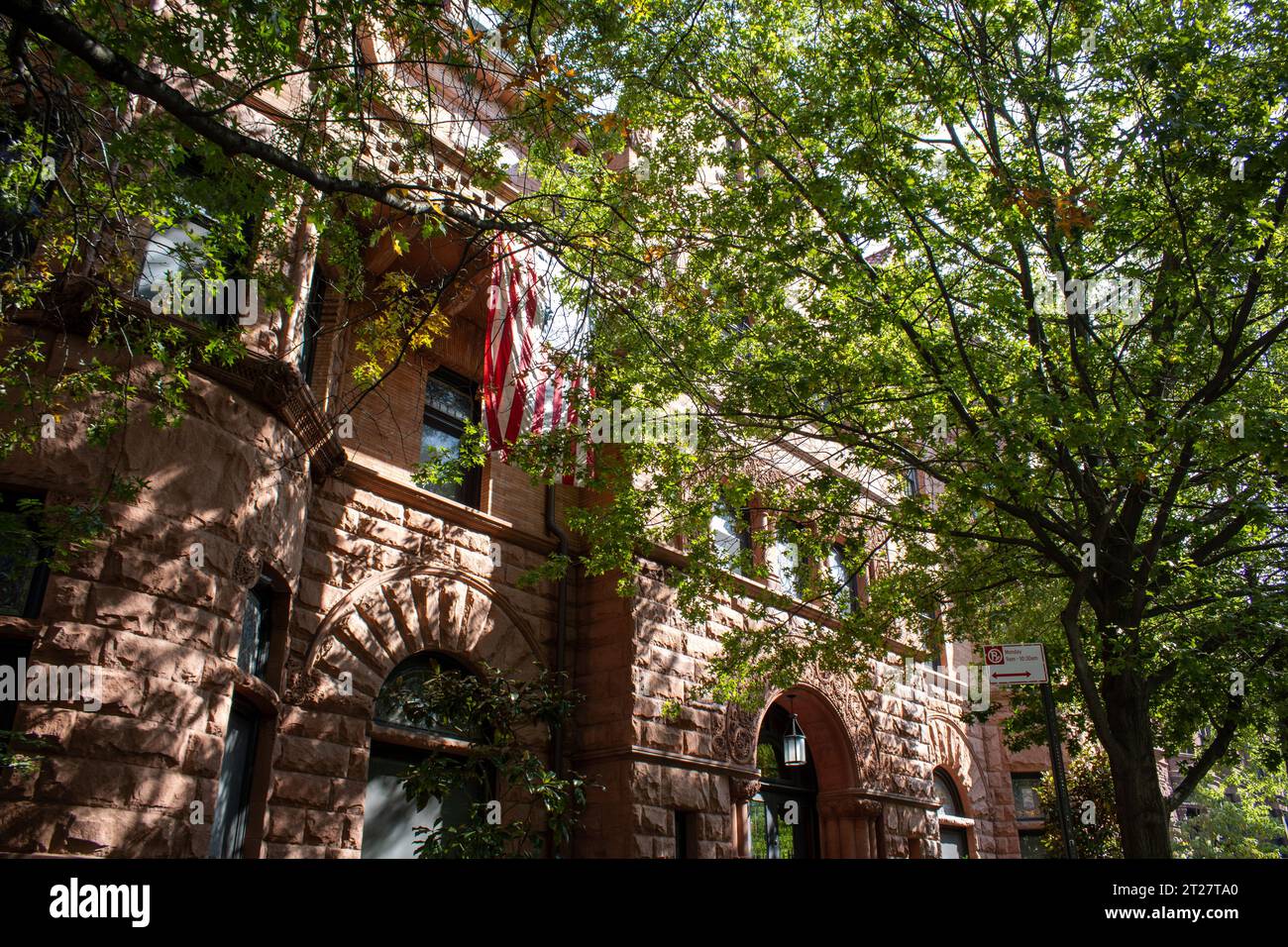 american flag hanging in brownstone building 3rd view Stock Photo - Alamy