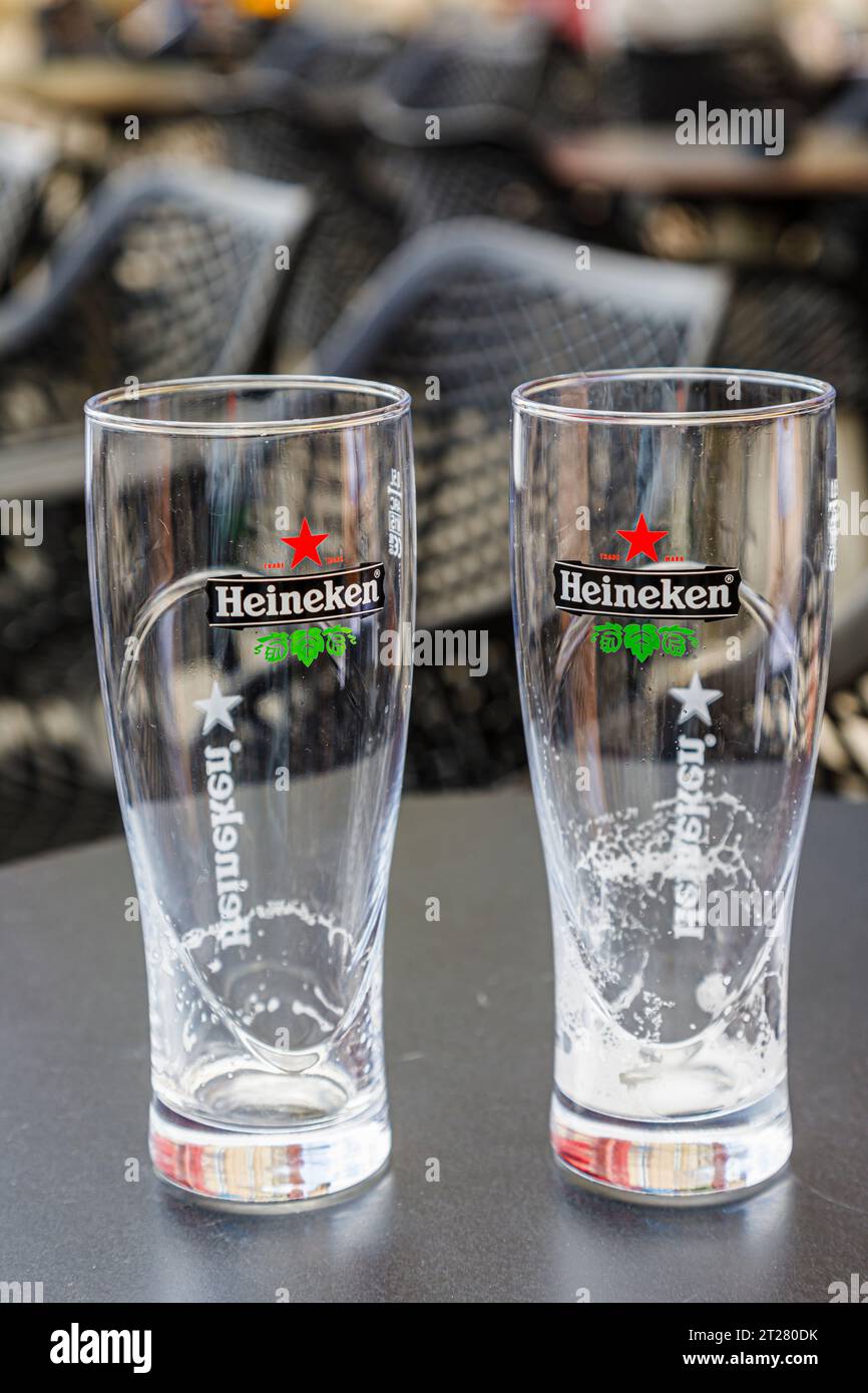 Two empty Heineken badged beer glasses on a table top in a cafe bar in ...