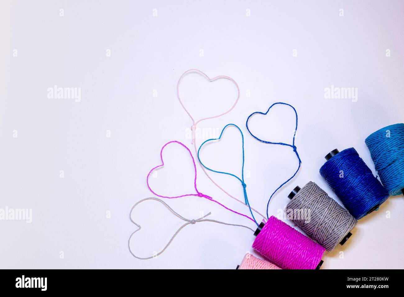 Conceptual art made with threads that form hearts on a light background ...
