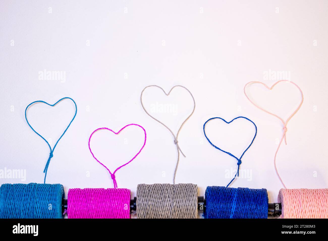 Conceptual art made with threads that form hearts on a light background ...