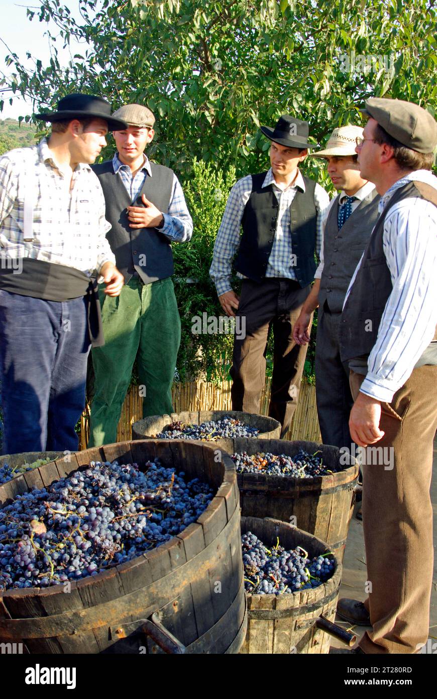 Five men in traditional peasant costume standing around wooden half ...
