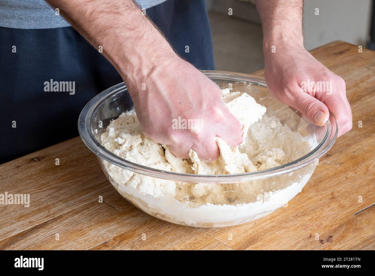 Man's hands kneading dough inside a glass bowl Stock Photo - Alamy