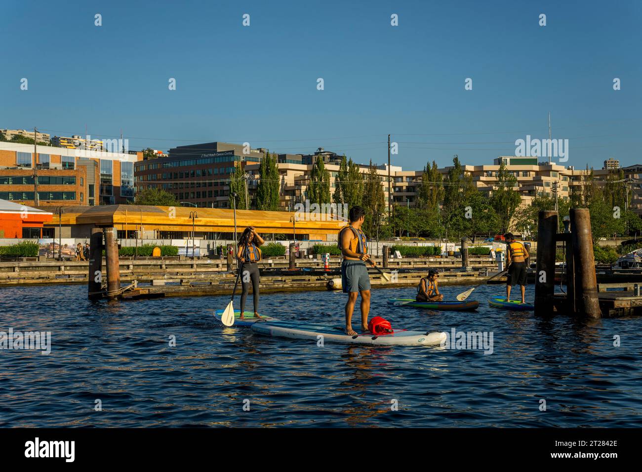 People paddle boarding on Lake Union with the Seattle skyline in ...