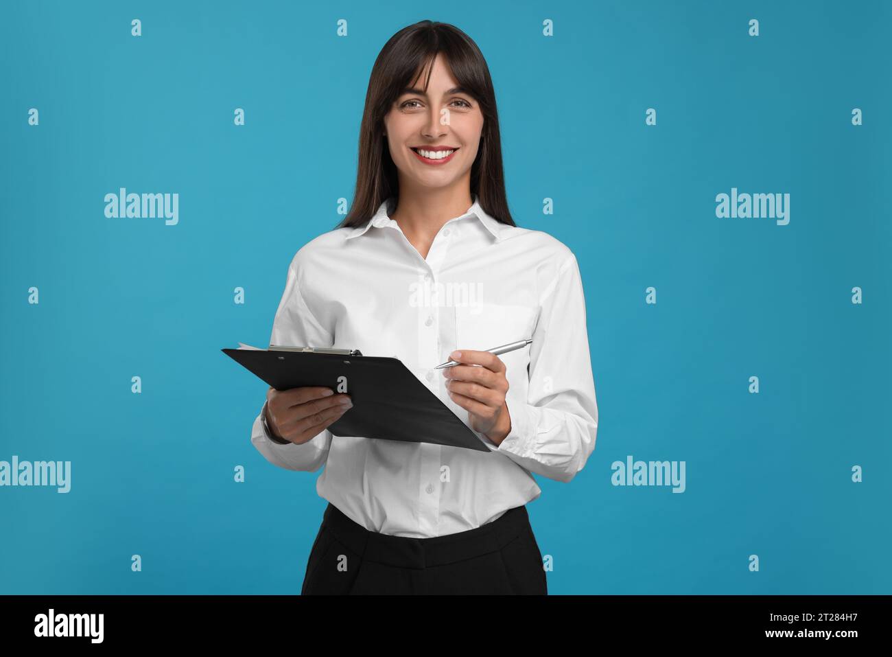Happy secretary with clipboard and pen on light blue background Stock ...