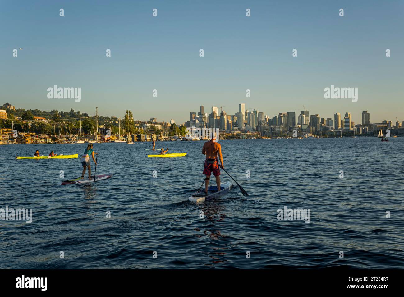 People paddle boarding and kayaking on Lake Union with the Seattle ...