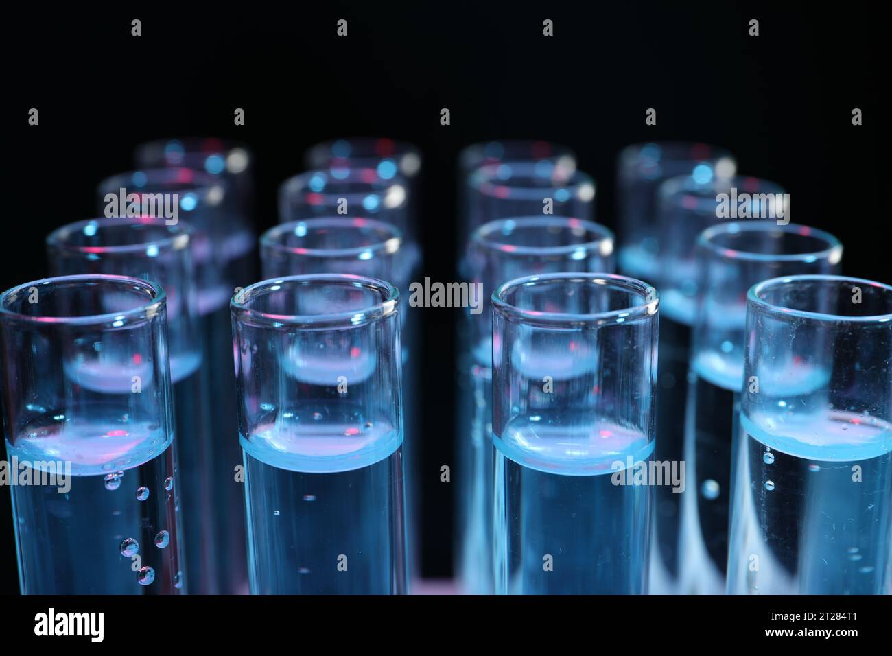 Test tubes with liquid on black background, closeup. Laboratory ...