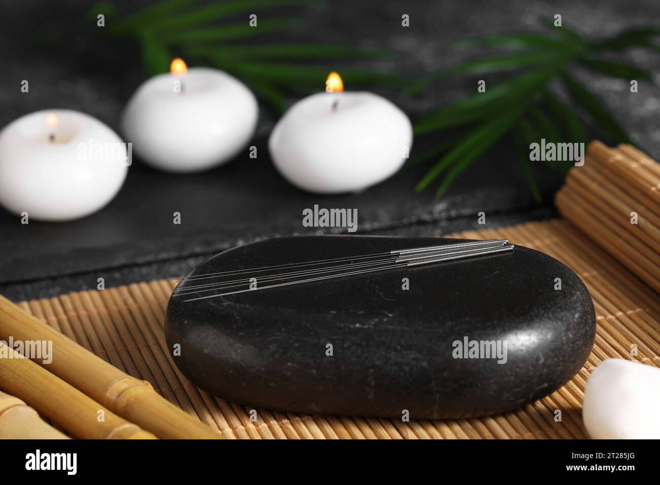 Stone with acupuncture needles on bamboo mat Stock Photo - Alamy