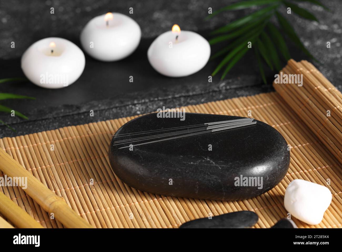 Stones with acupuncture needles on bamboo mat Stock Photo - Alamy