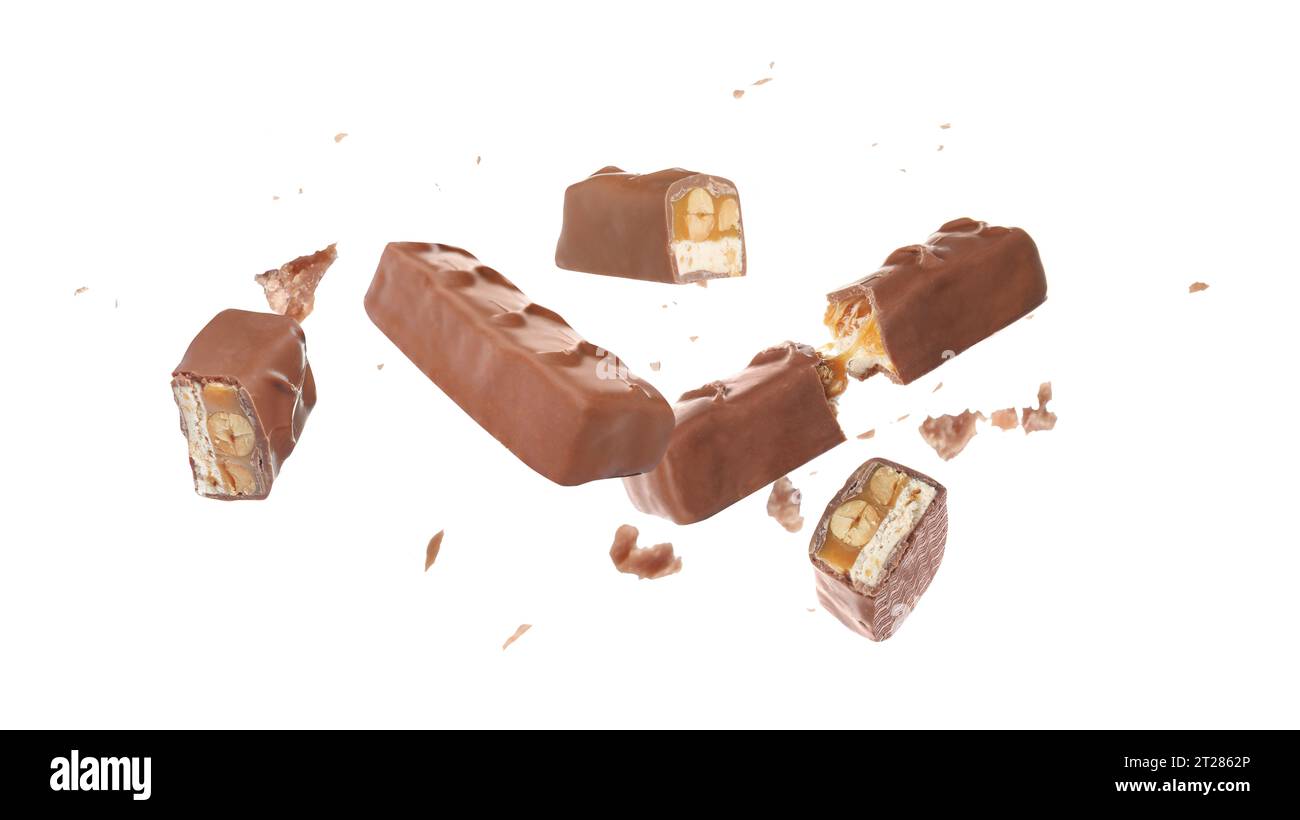 Whole and broken chocolate bars with caramel, nuts and nougat falling ...