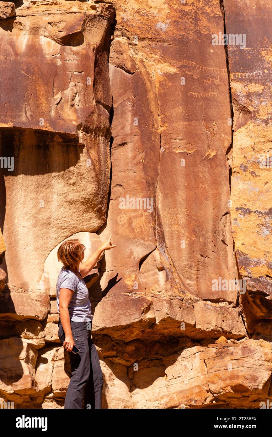 A woman explores the Fremont petroglyphs of Nine Mile Canyon ...