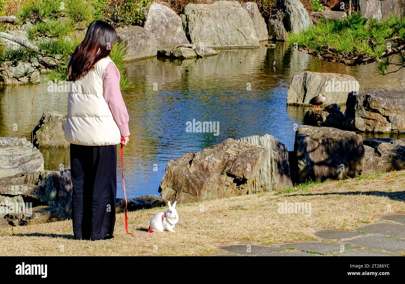 A young female wearing cozy winter attire leisurely walking around a ...
