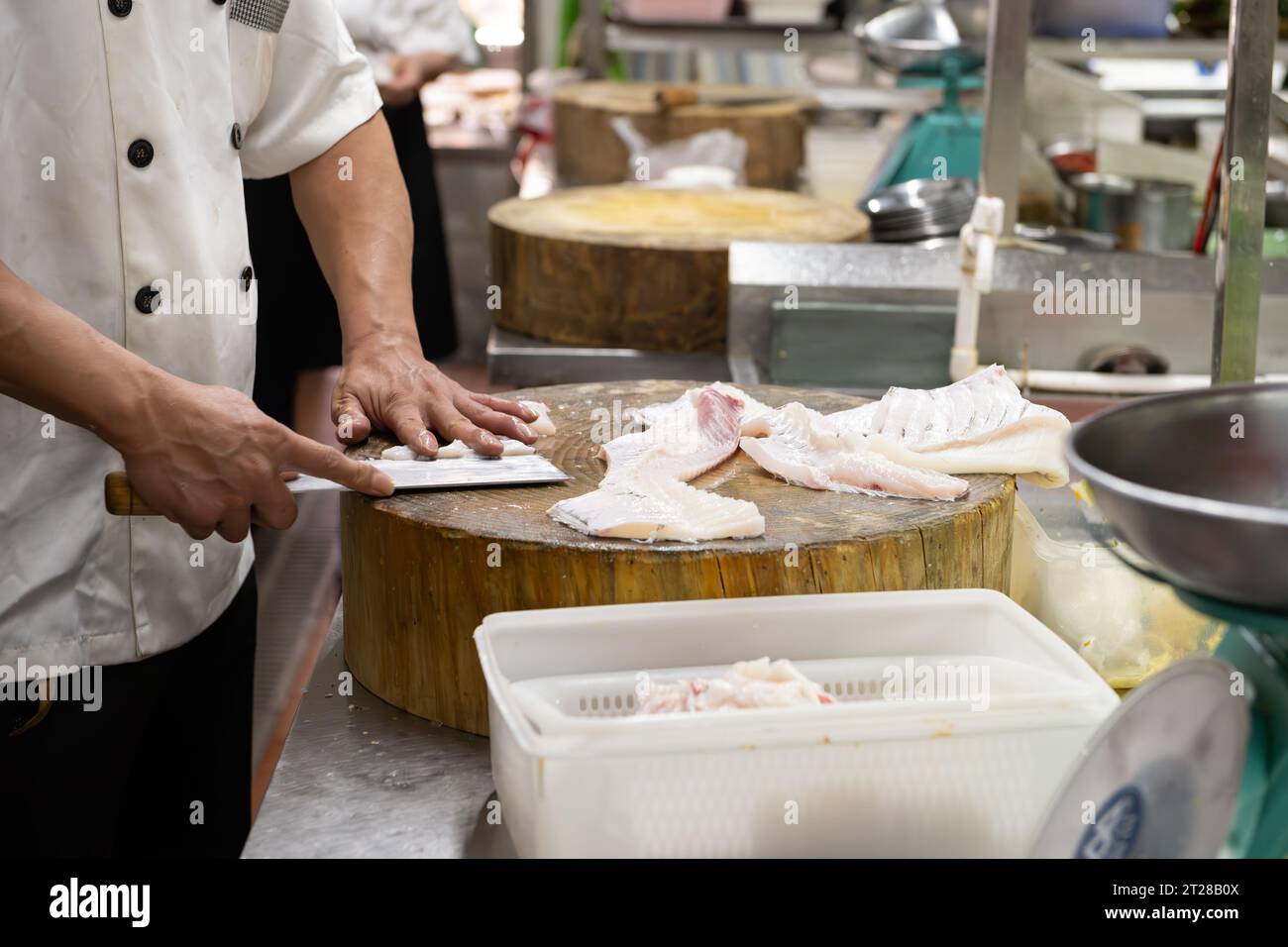 chief cutting fish in a kitchen Stock Photo - Alamy