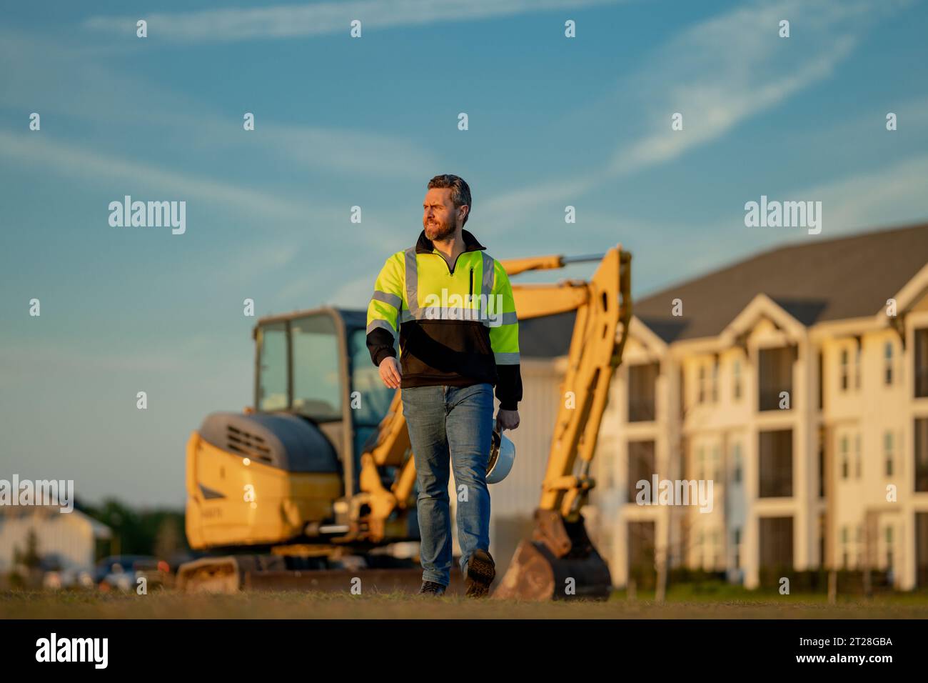 Builder in a construction site. Builder with excavator ready to build ...