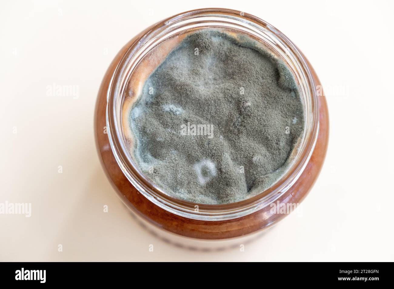 Open jar with sweet jam and mold on a white background Stock Photo - Alamy