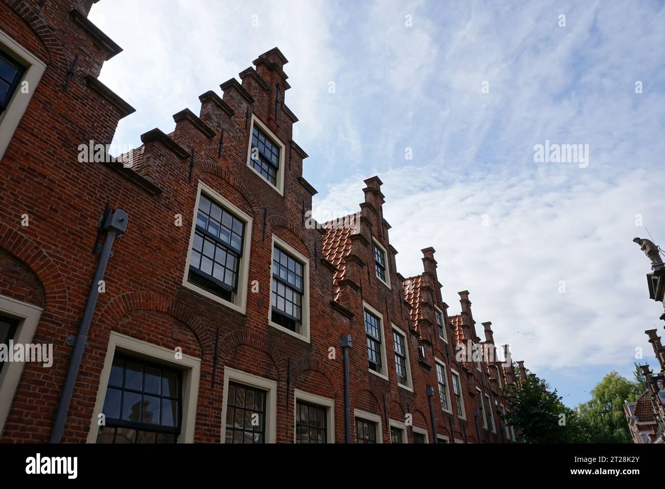 A row of typical traditional Dutch old fashioned gable roof brick ...