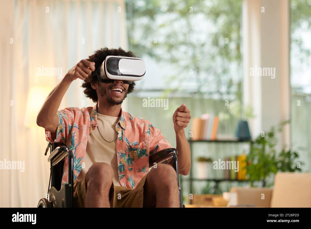 Excited man with disability playing racing videogame in vr headset ...