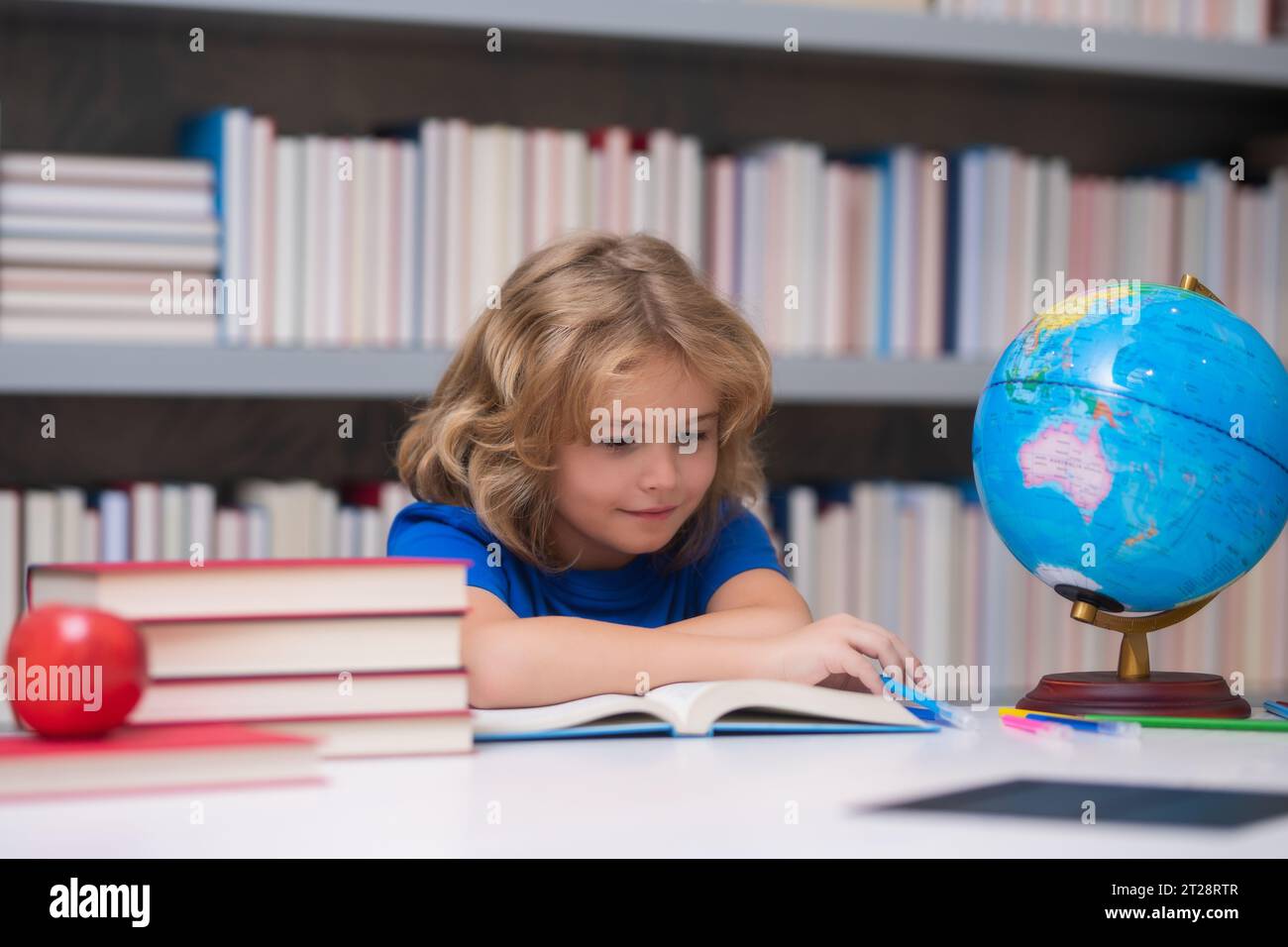 Elementary school boy. School kid with pile of books. Children enjoying ...