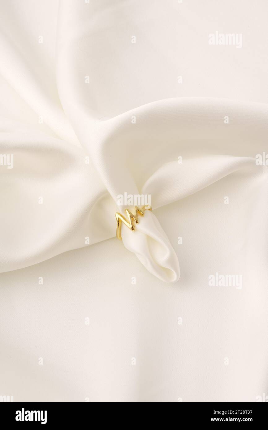 Golden ring on white silk cloth background Stock Photo - Alamy