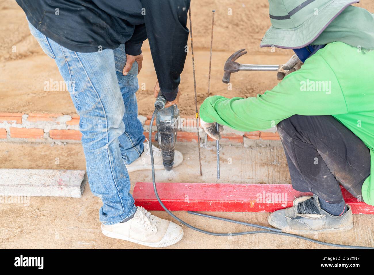 Worker drilling hole and hit steel rod for install structure concrete ...