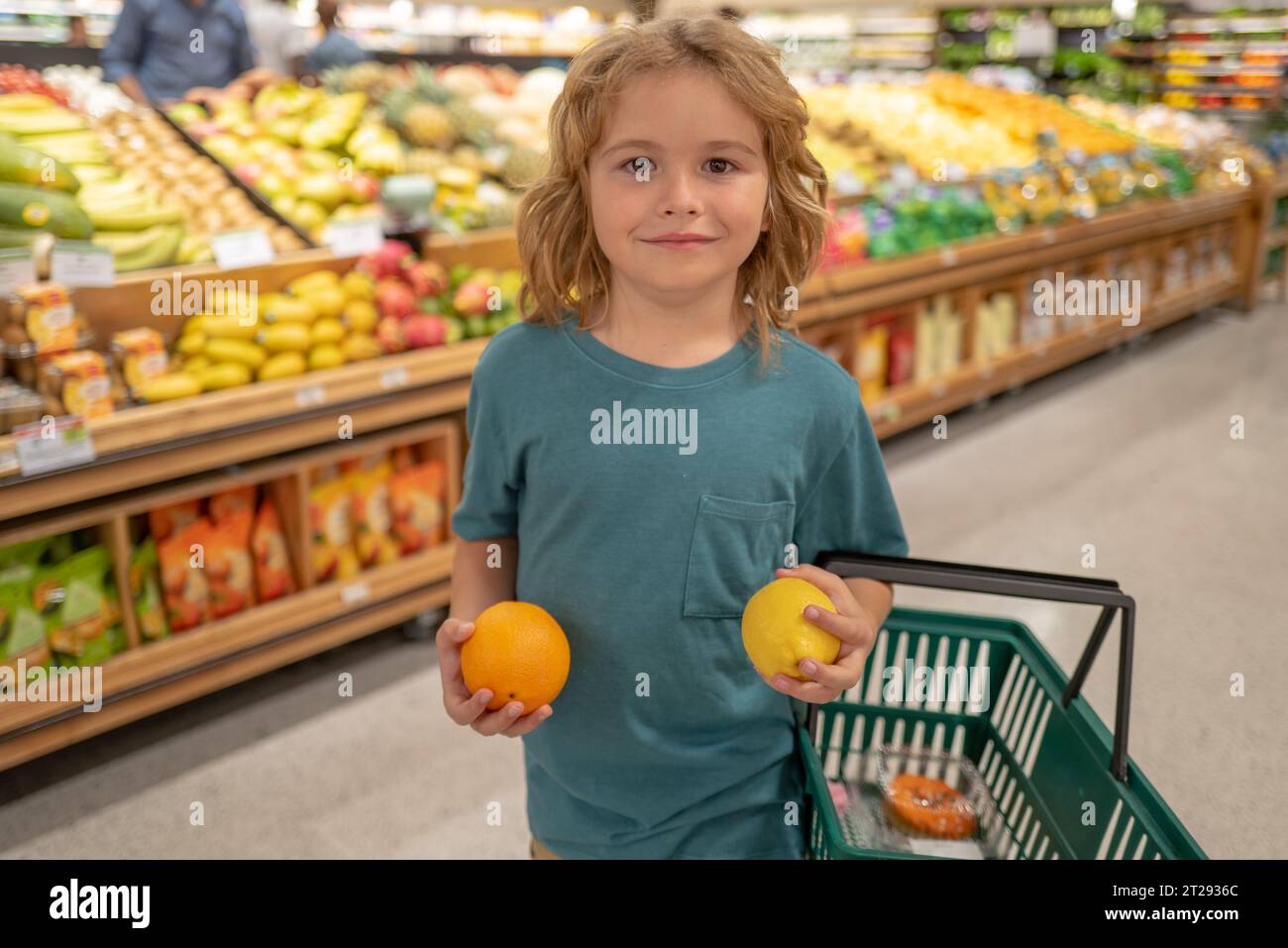 Kid on shopping in supermarket. Child with lemon and orange. Grocery ...