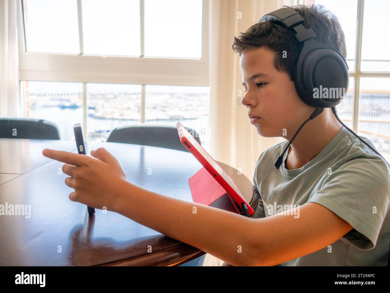 Cute little boy using smartphone, lying on cozy couch, relaxing on ...