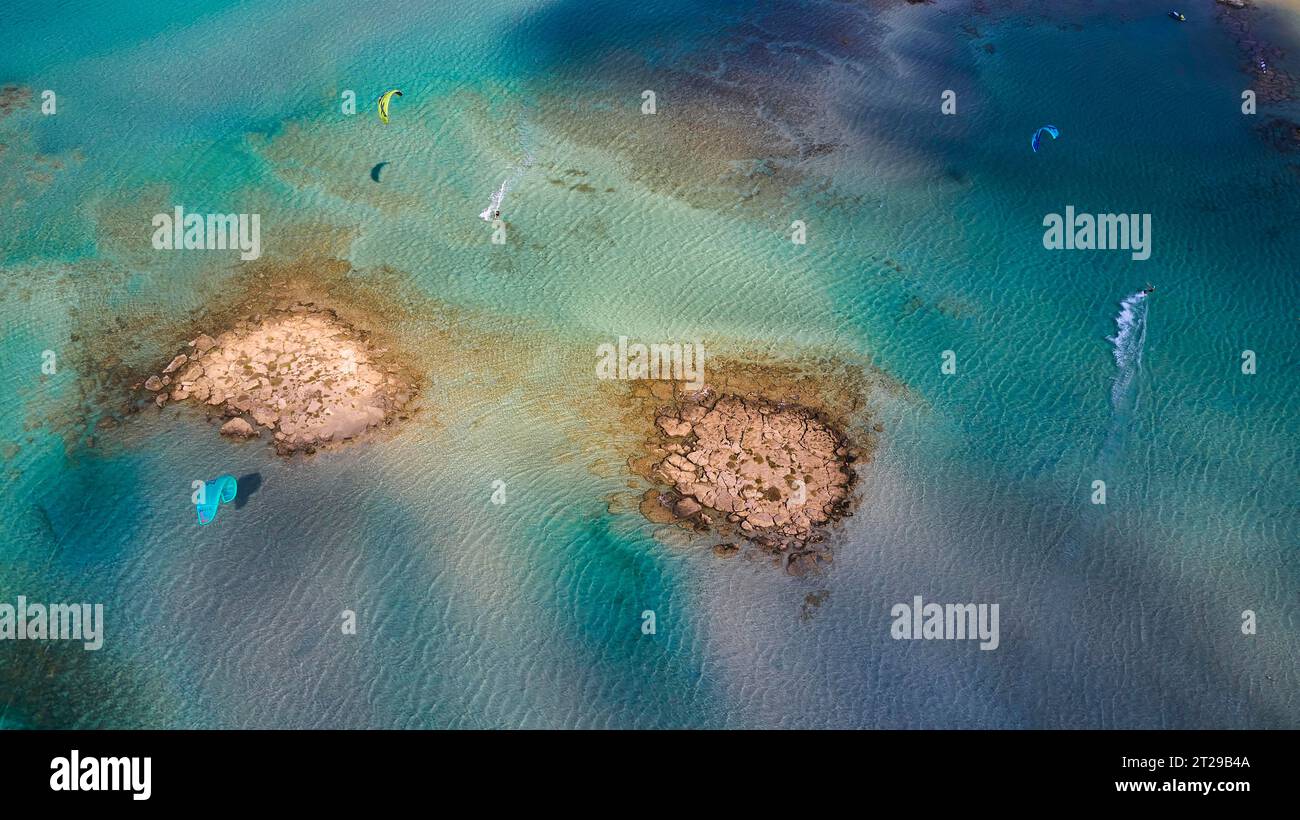 Glider over Elafonissi, drone shot, round rocky reefs, turquoise sea ...