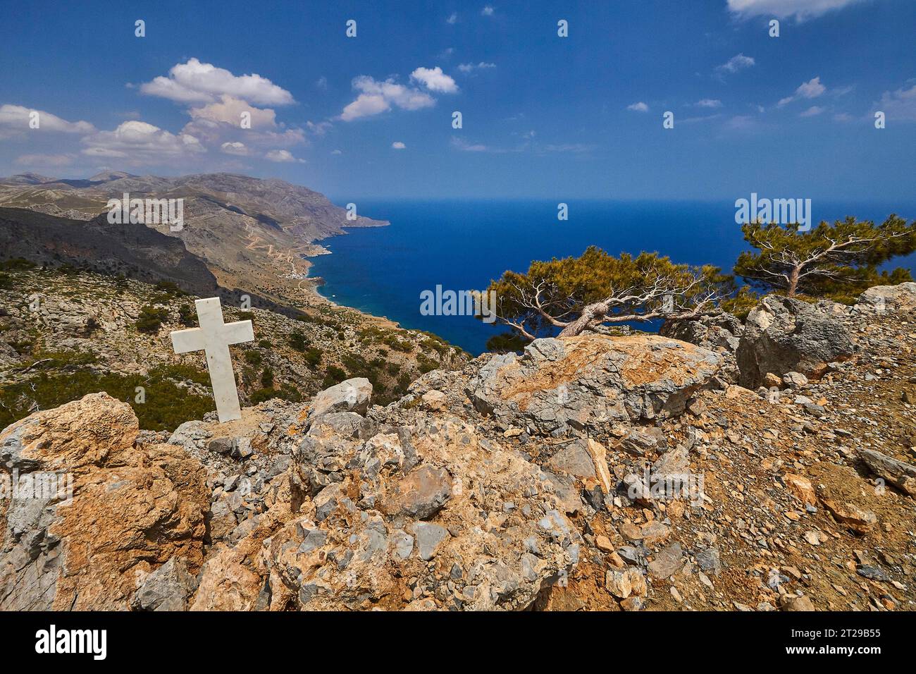 Rugged south coast, wayside cross, windswept trees, rocks, blue sky ...