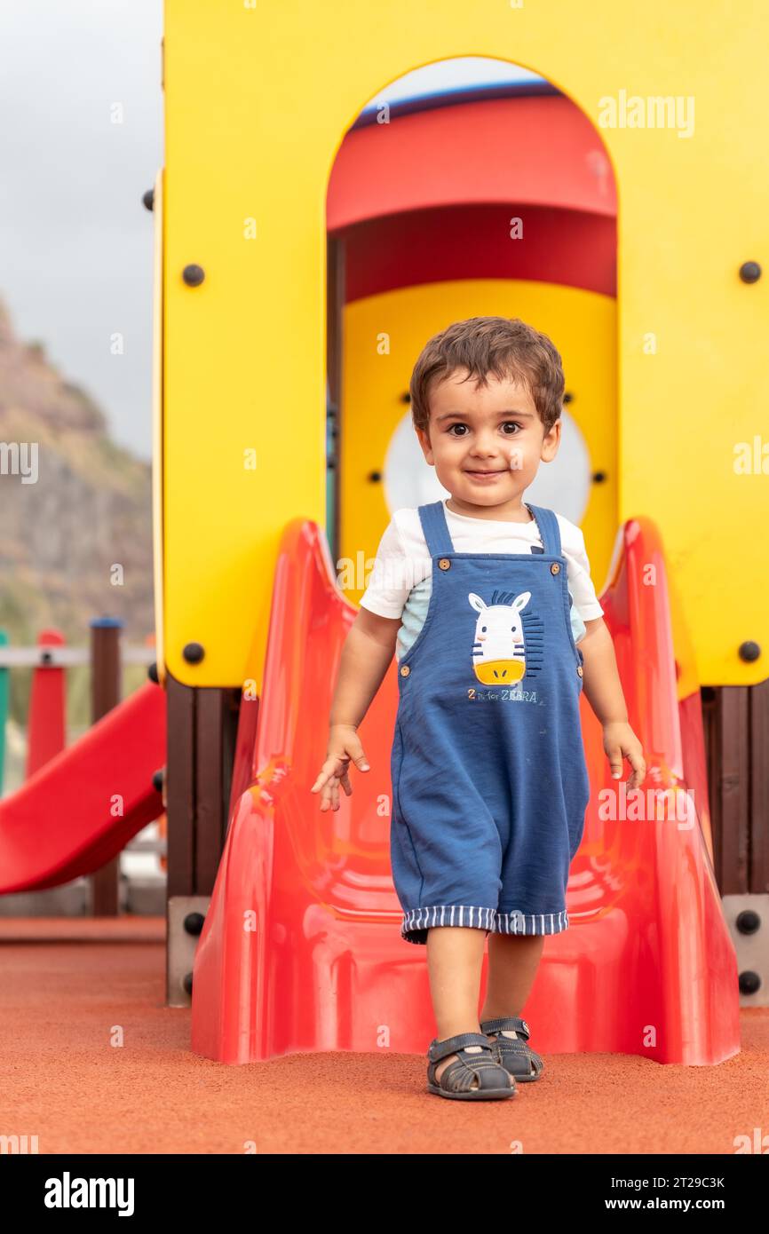 Baby playing in a playground having fun in summer, park for young ...
