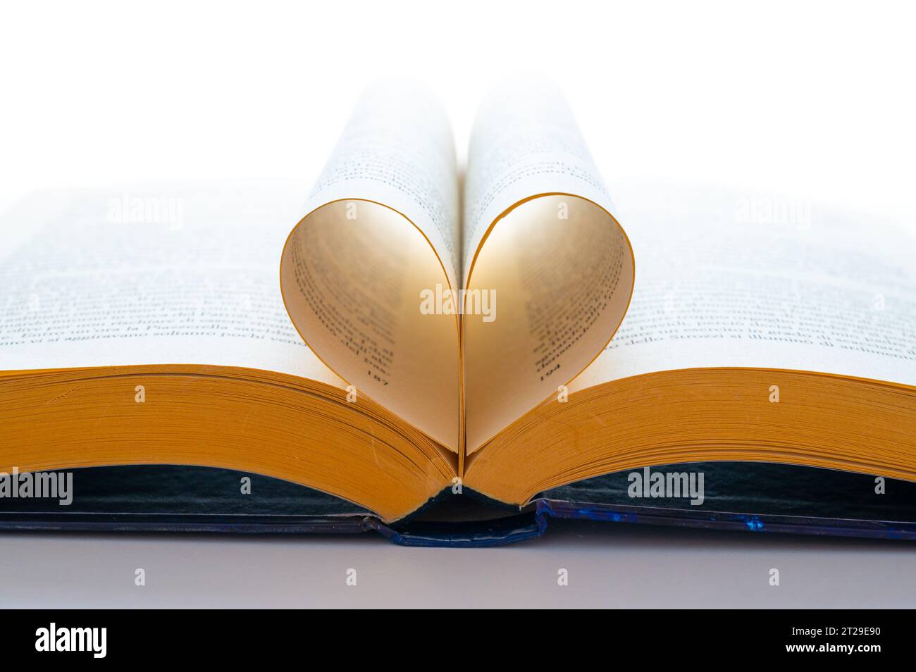 Open book and pages folded to form a heart, on a white background. Love ...